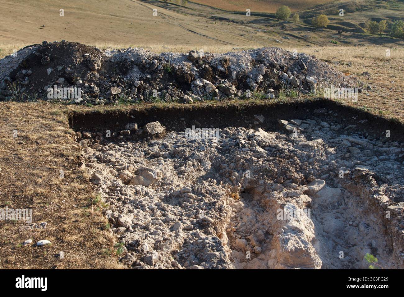 Exposed archaeological dig site showing soil layers and chalky surface ...