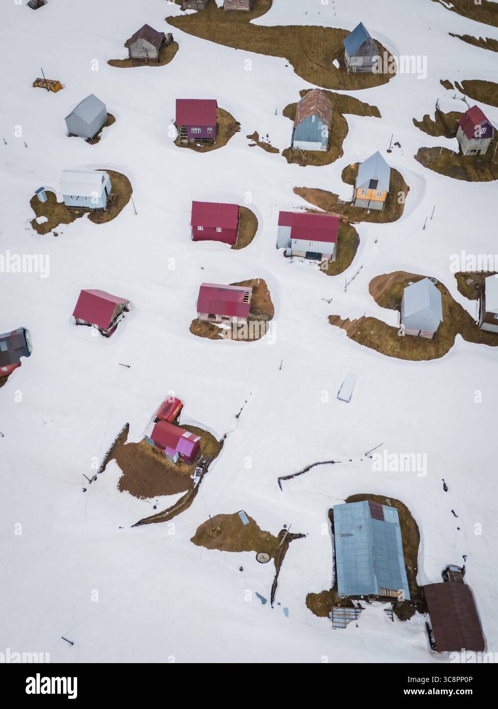 Aerial view of rustic cabins with red and silver roofs scattered across ...