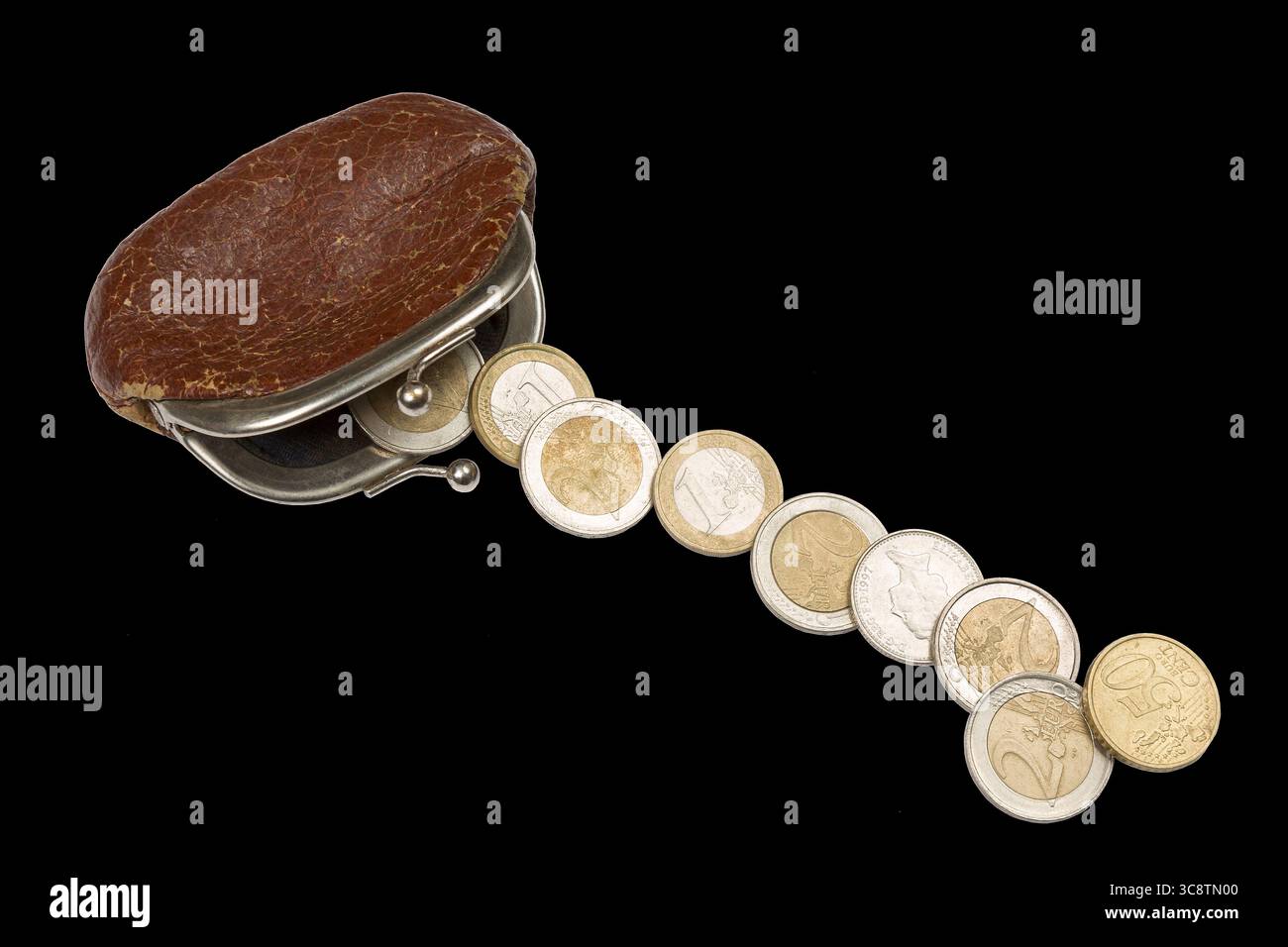 Vintage brown change purse and euro coins isolated on black background ...