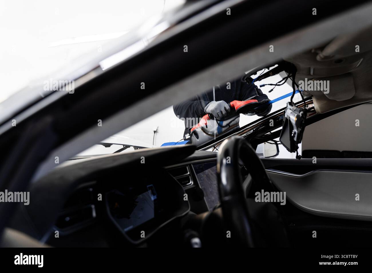 Two technicians install windshield using suction lifters. Windshield ...