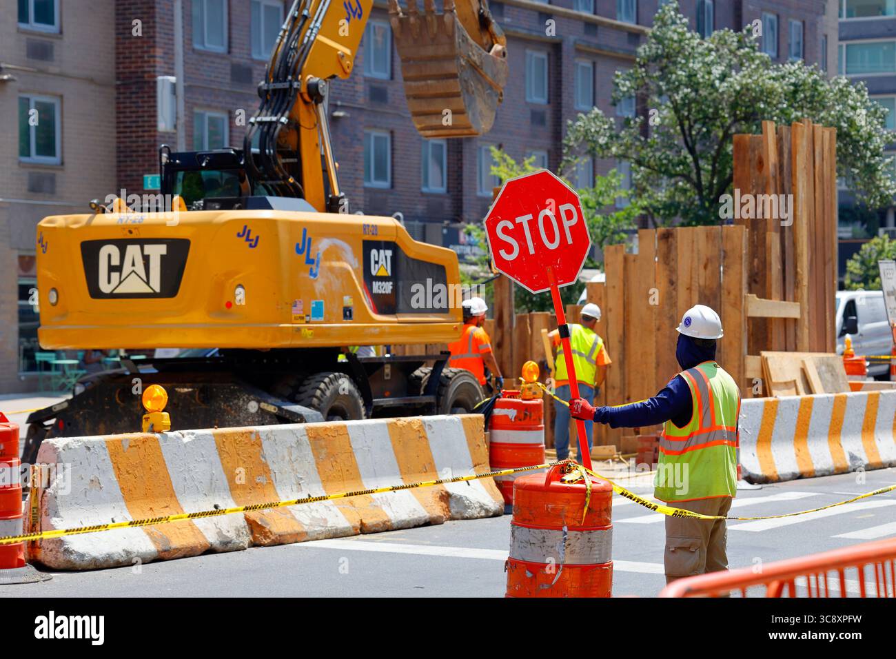A traffic controller, or construction flagger, holding a stop sign at a ...