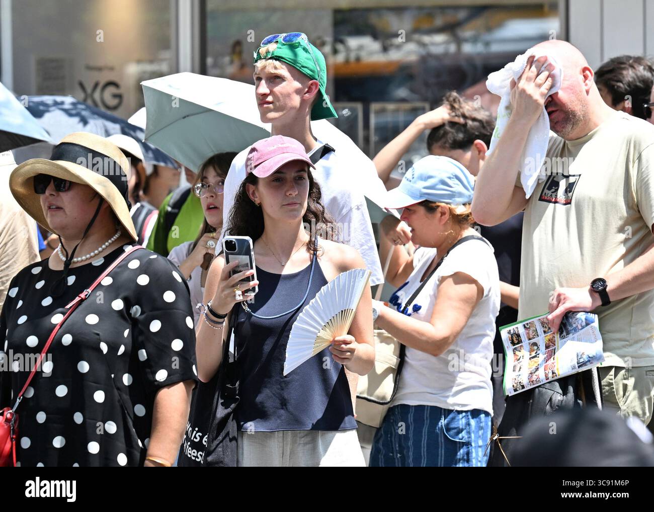 People walk during the intense heat in Shibuya Ward, Tokyo on August 5 ...