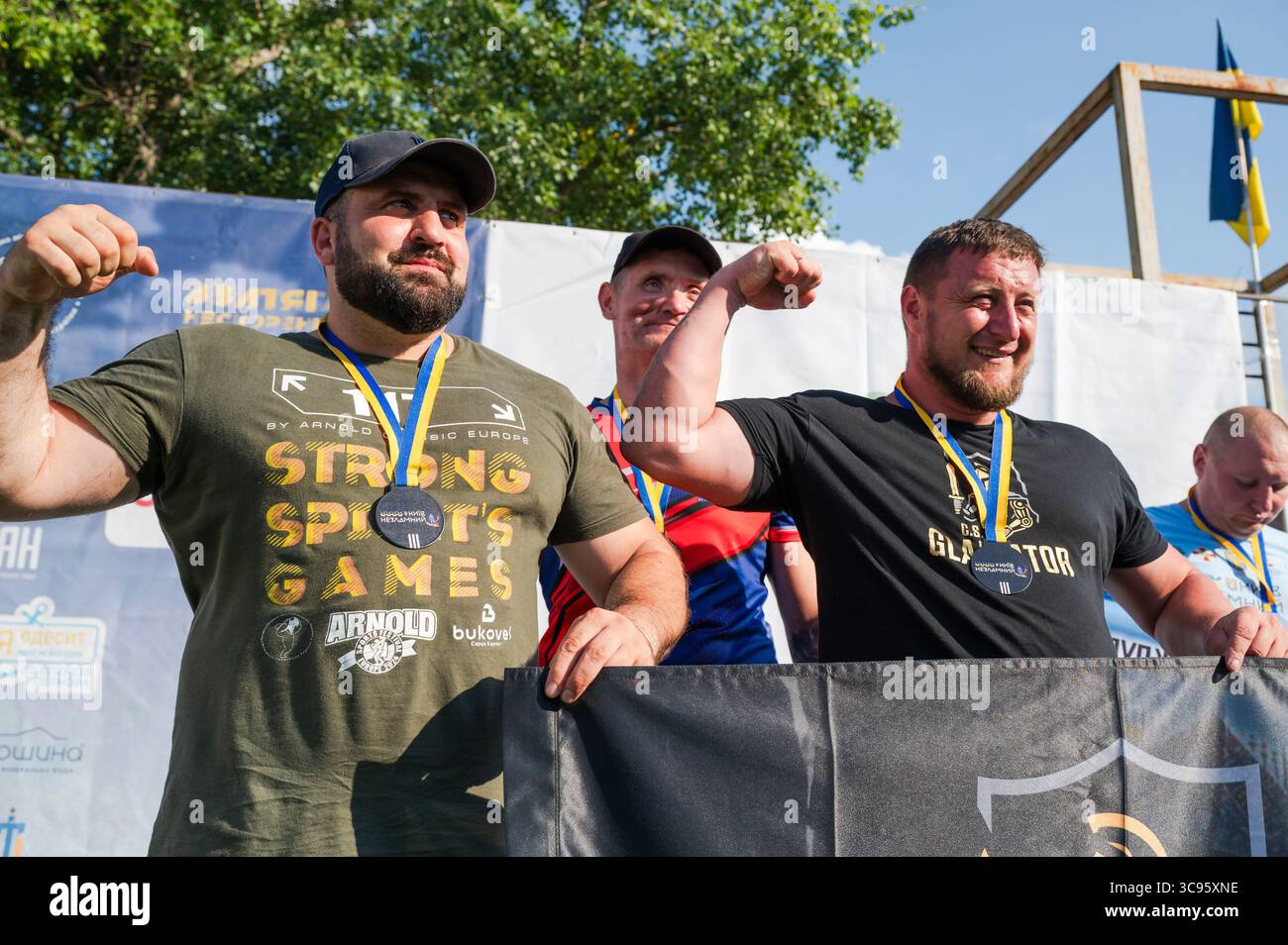 Kyiv, Ukraine - 2d August, 2025: Three strongmen flexing their biceps ...
