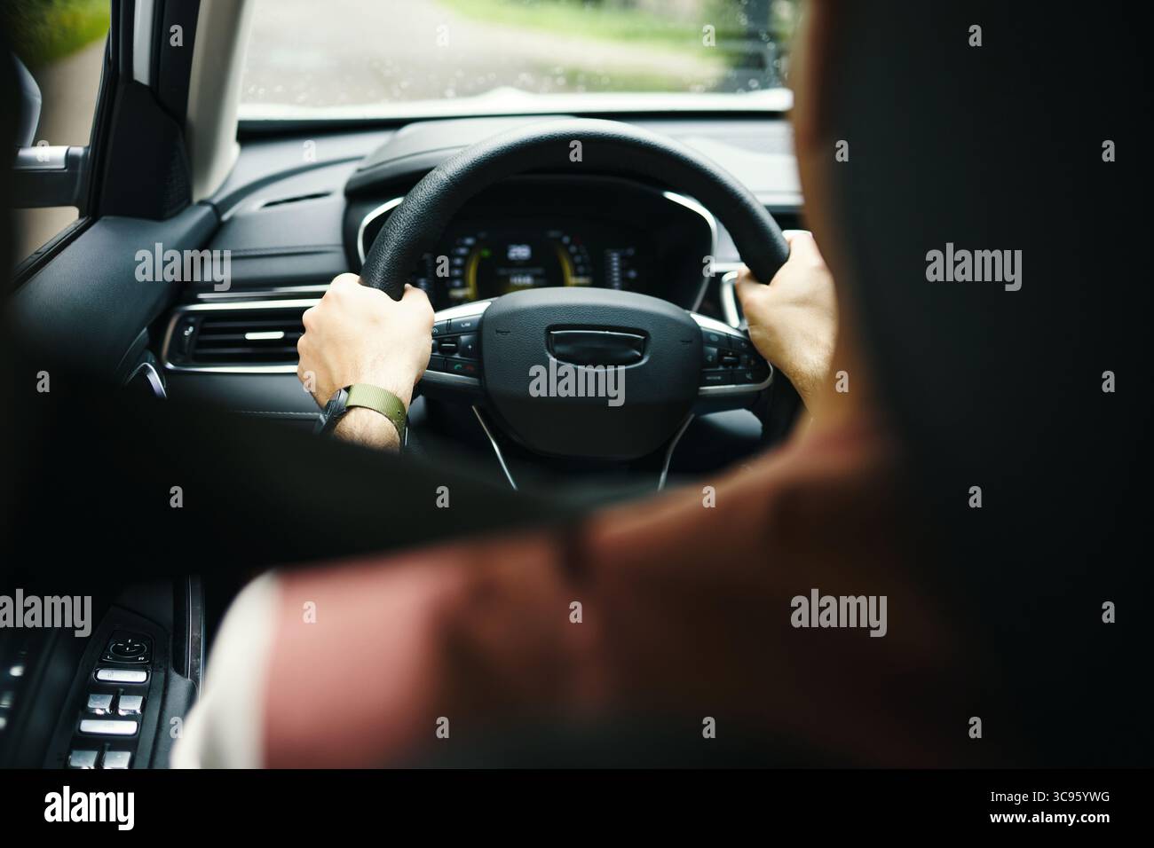 Caucasian young adult man driving car during family road trip, hands ...