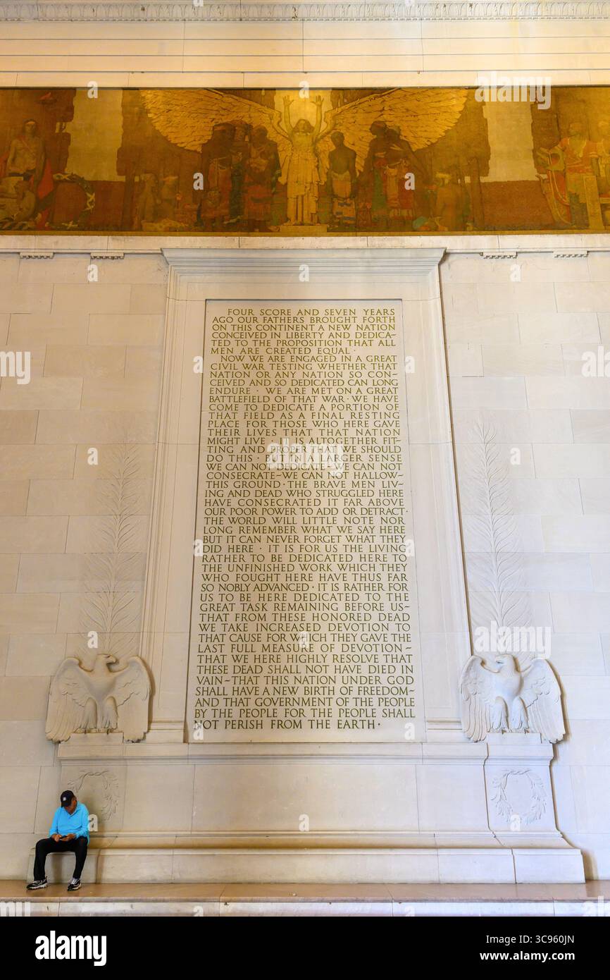 A Gentleman Using His Mobile Phone Sits Underneath The Inscription Of ...