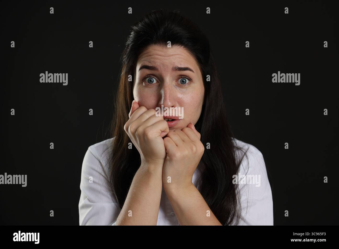 Woman suffering from panic attack on black background Stock Photo - Alamy