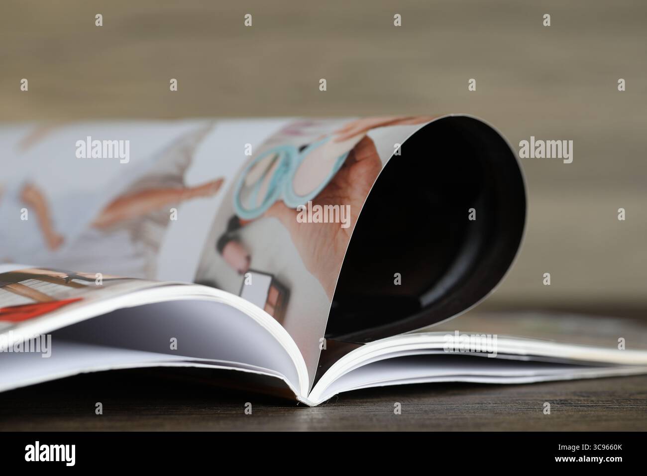 One open magazine on wooden table, closeup Stock Photo - Alamy