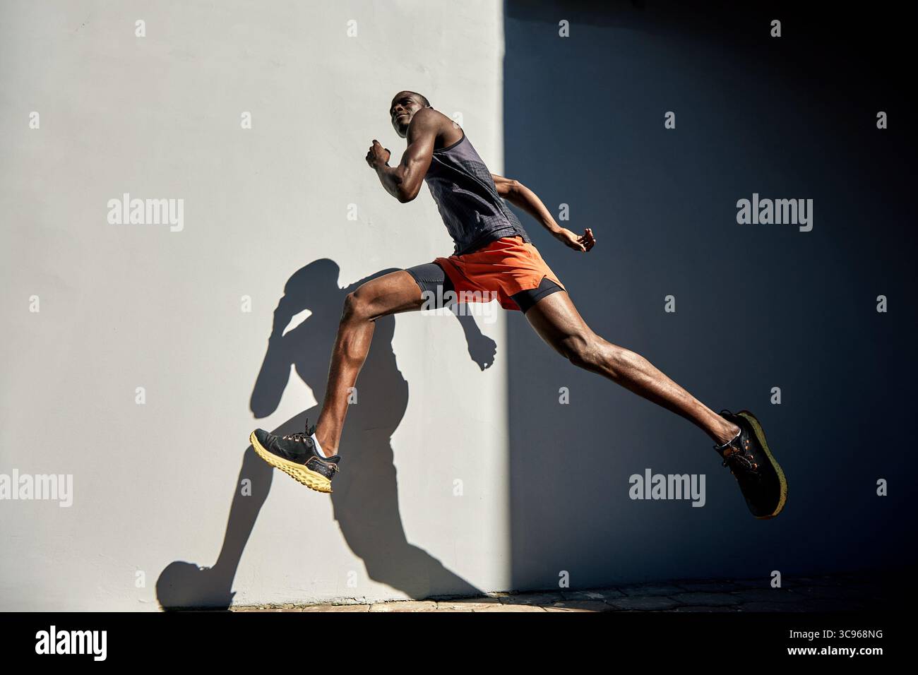 A fit individual captured in action poses dynamically sprinting against ...
