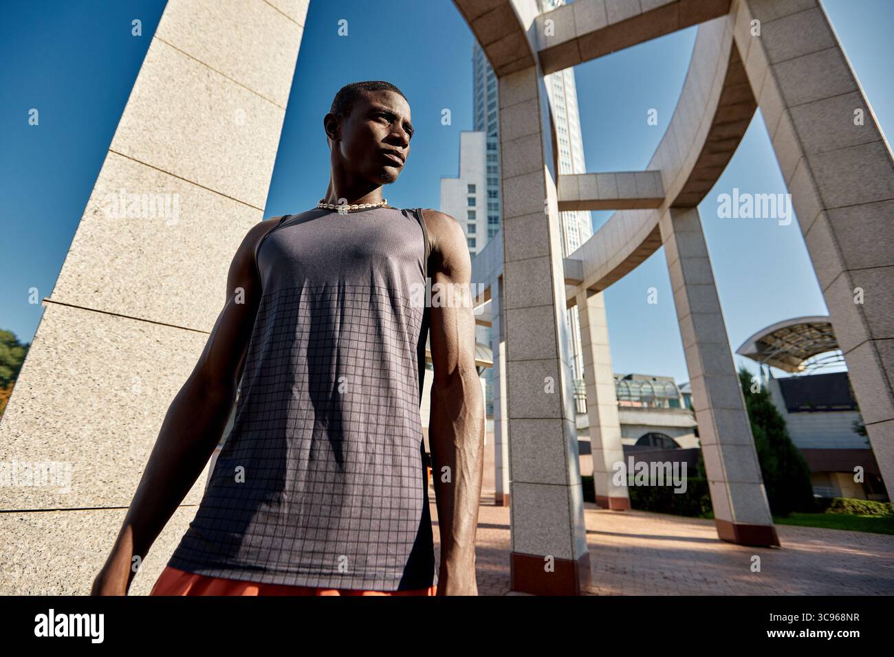A strong and confident man dressed in athletic attire stands amidst ...