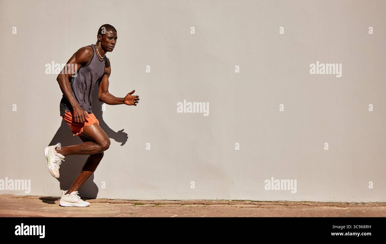A determined man in motion, showcasing athleticism and strength while ...