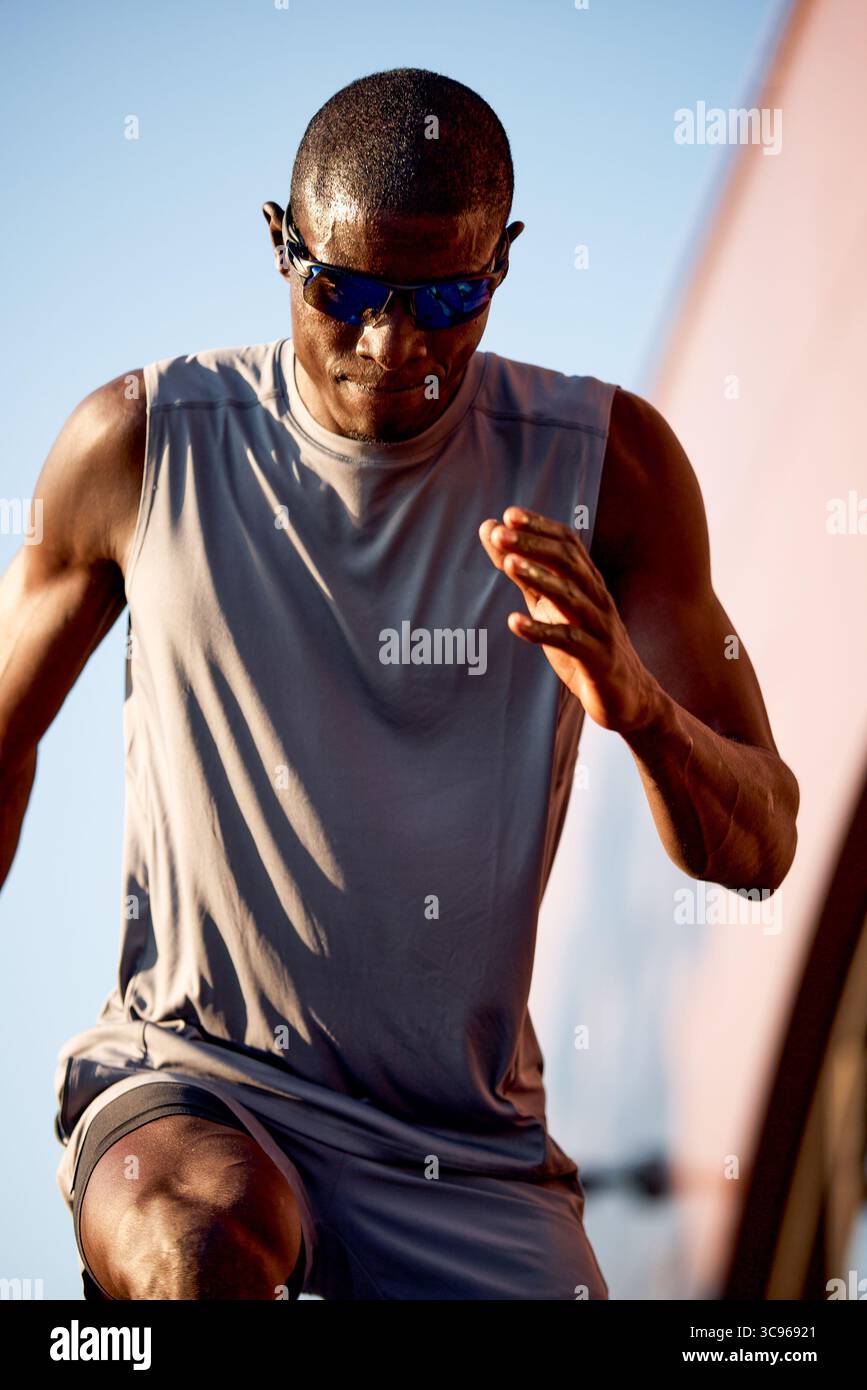 A determined athlete running outdoors during the day, showcasing energy ...