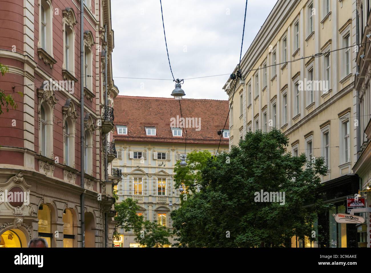 View of ornate buildings rise on either side of a narrow street, their ...
