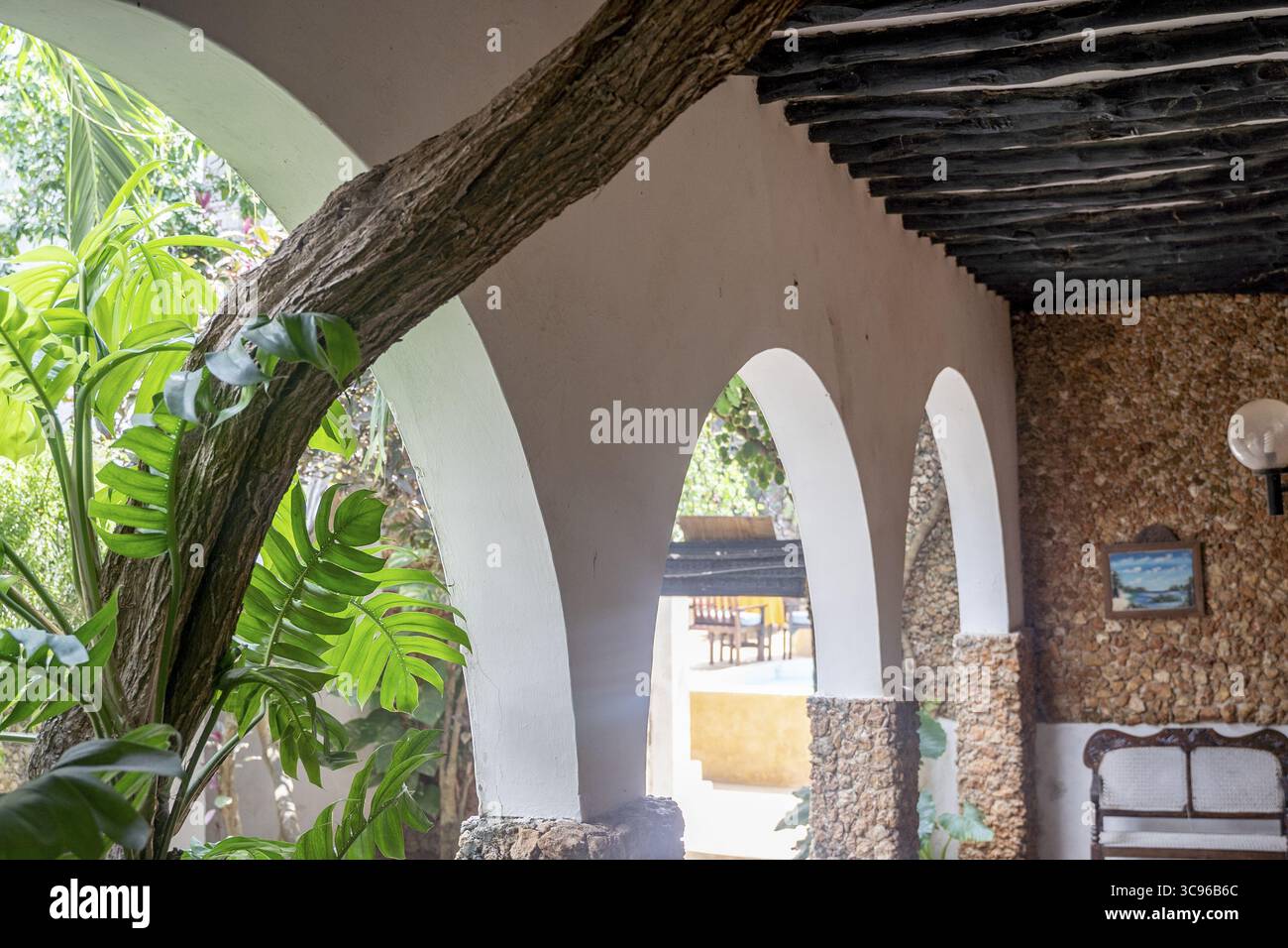 View of white arches framing a glimpse of outdoor seating, complemented ...