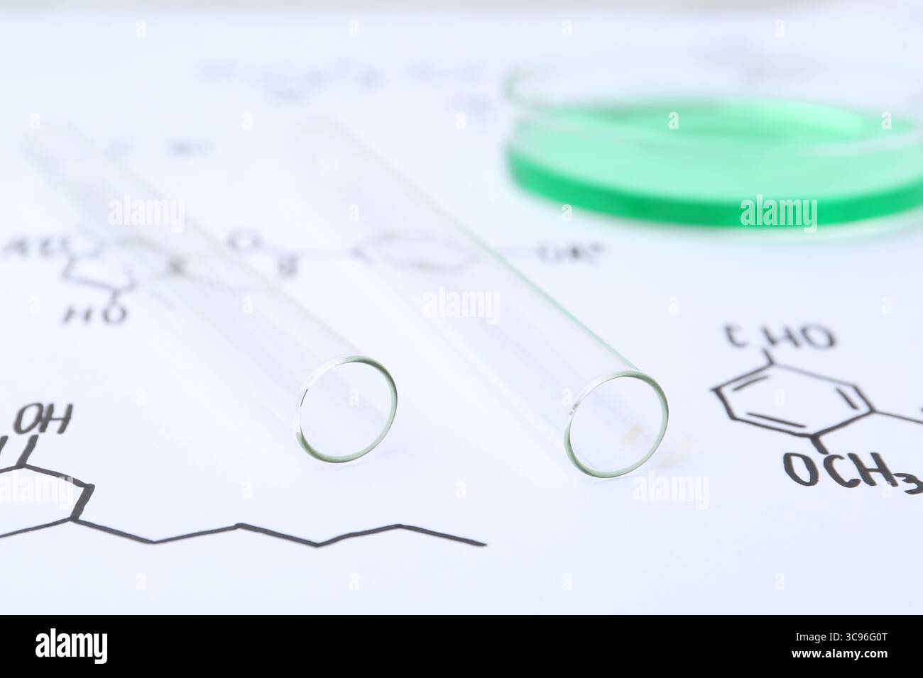 Test tubes and Petri dish of sample on paper with chemical formulas ...