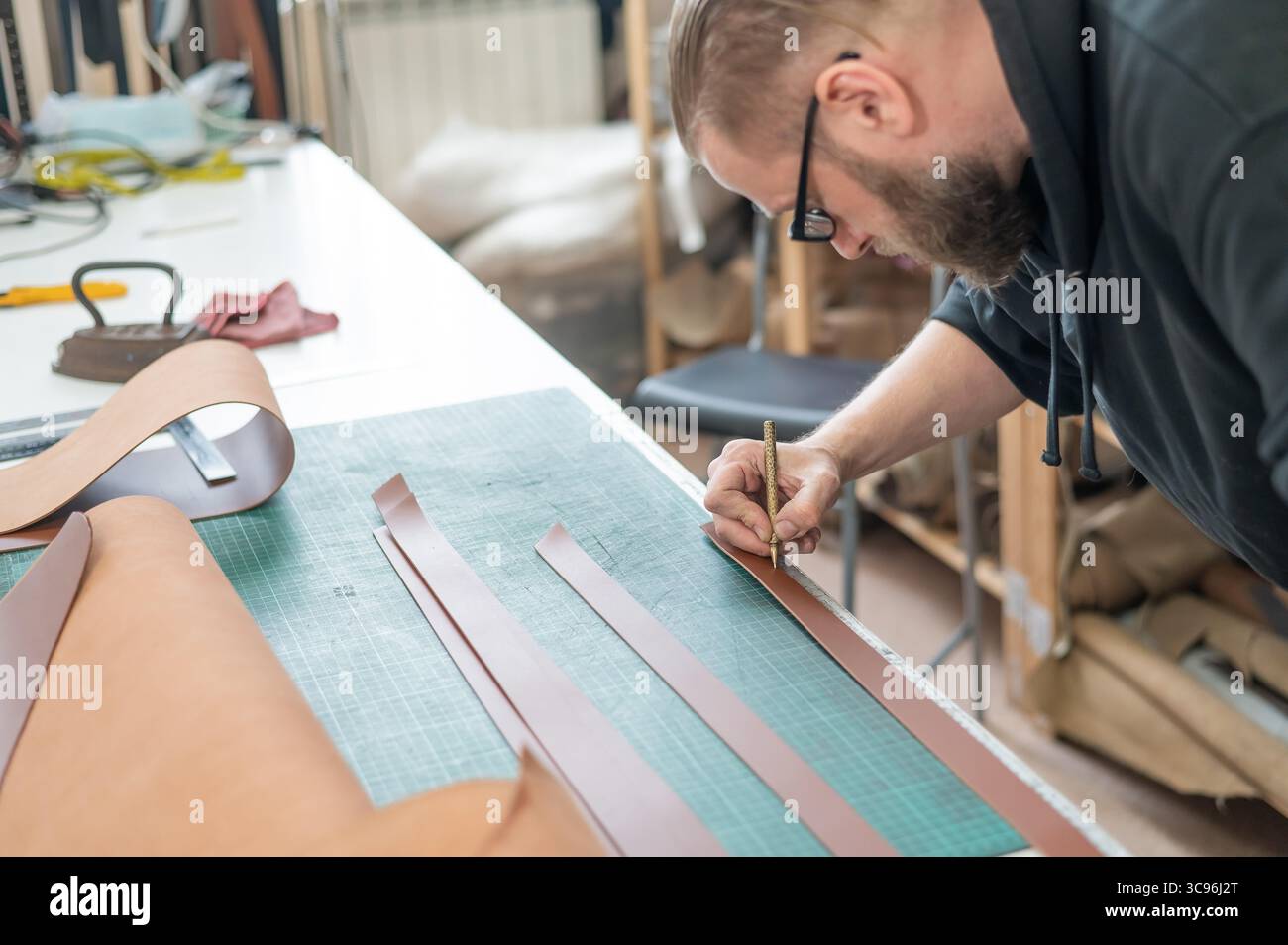 Caucasian bearded man working as a tanner in a workshop Stock Photo - Alamy