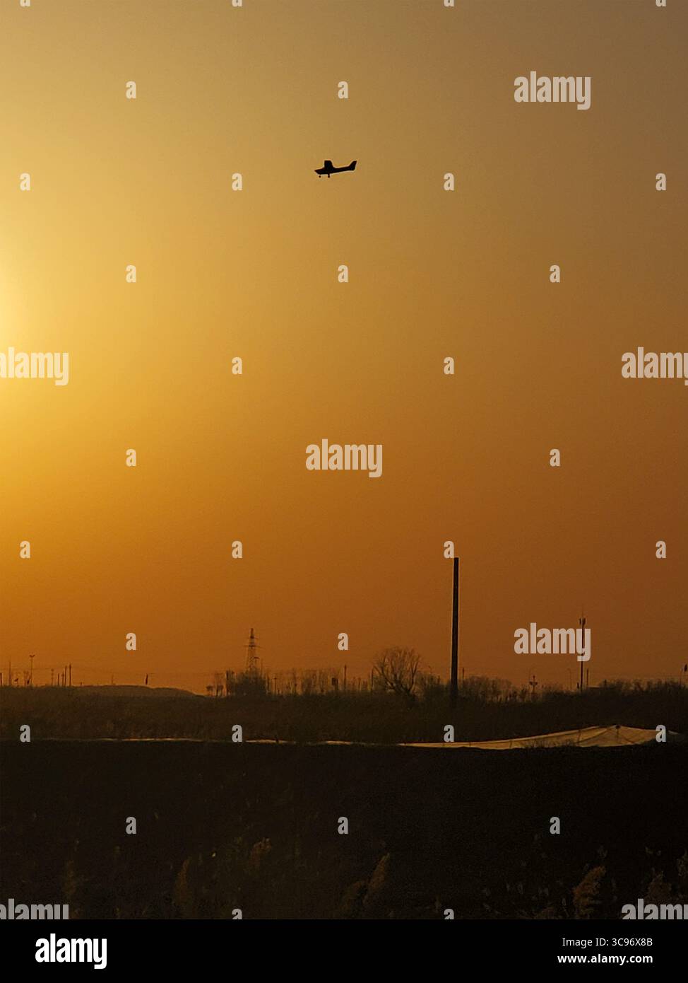 Lone Light Aircraft Silhouette Over Sunset Wetlands Stock Photo - Alamy