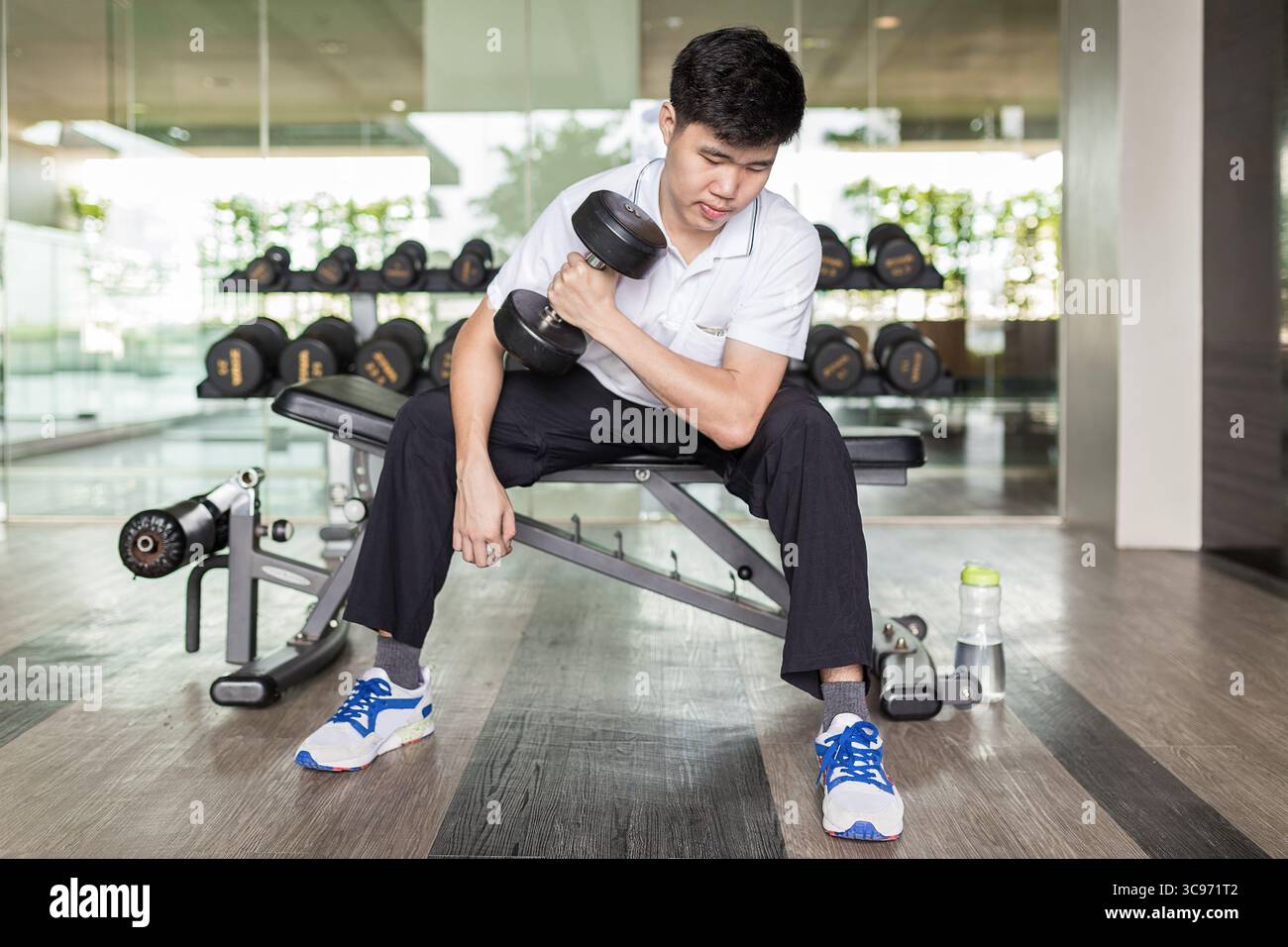 A handsome power athletic man bodybuilder doing exercises with dumbbell ...