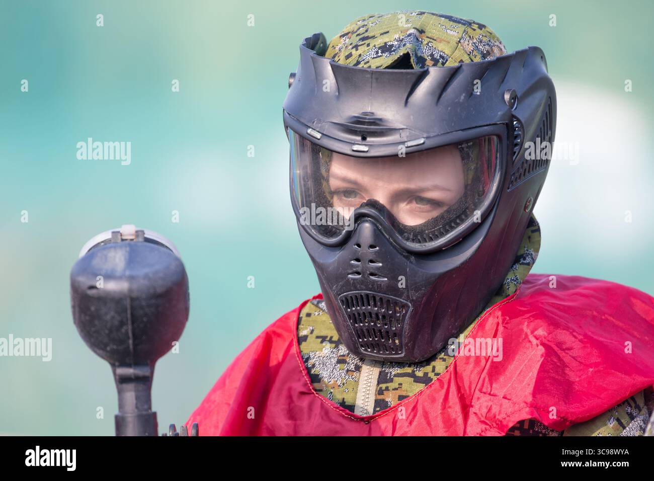 Paintball sport player in protective uniform and mask close up portrait ...