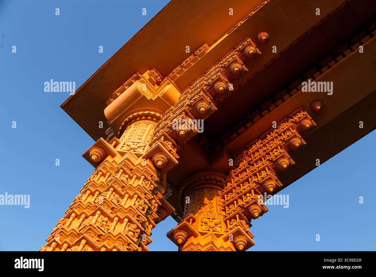 Ornately carved stone pillars supporting a modern roof structure ...
