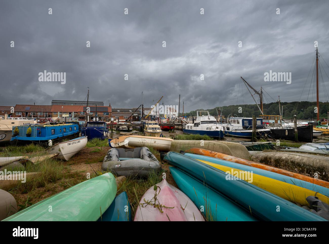 Colorful boats under a stormy sky. View of the quay on the River Deben ...