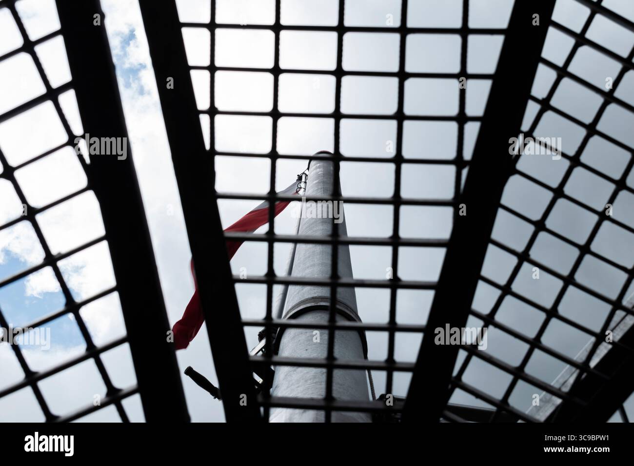 Shot from below the mesh stairs showing mast tower with Polish flag ...