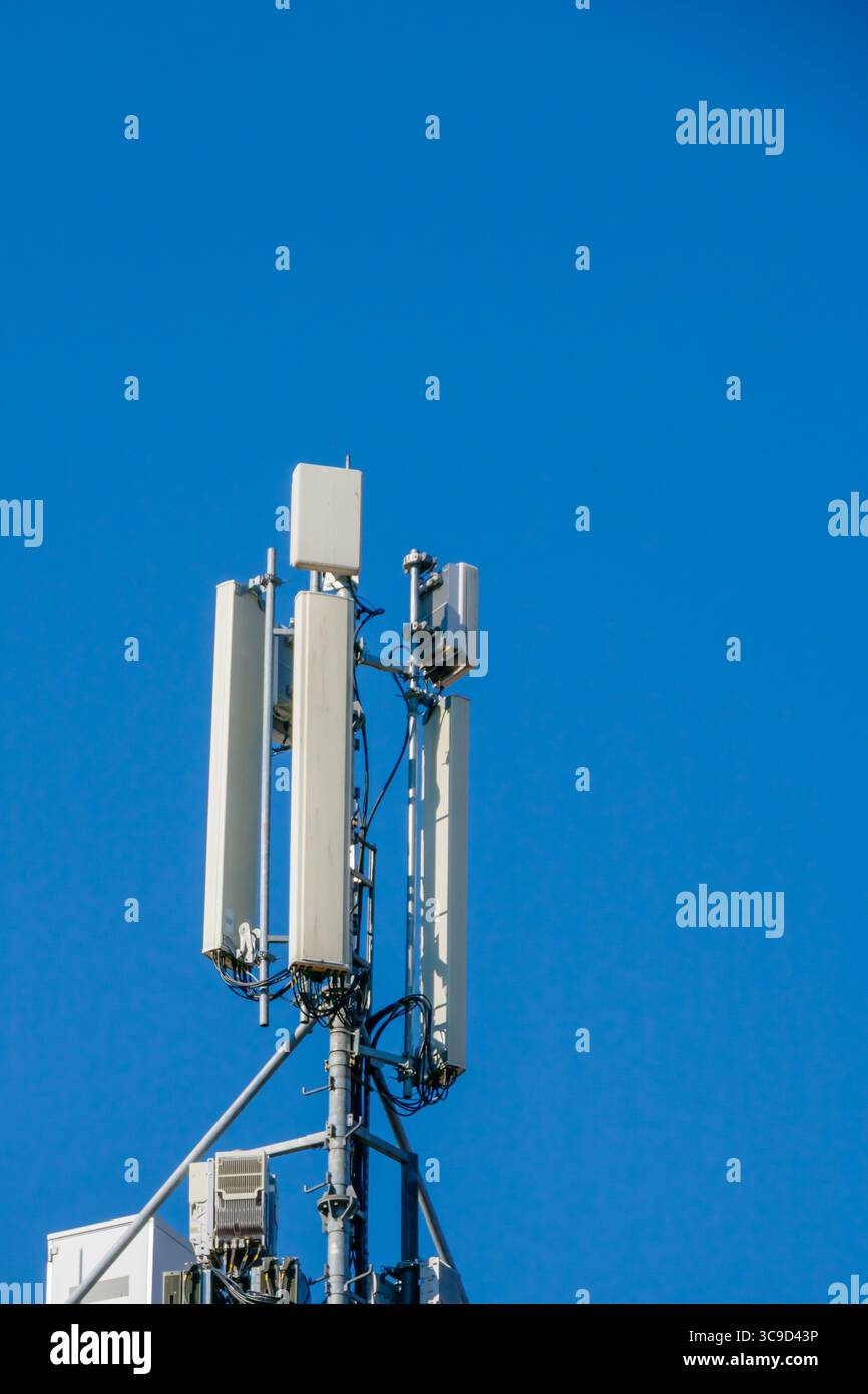 A close-up of a modern telecommunication tower equipped with white ...