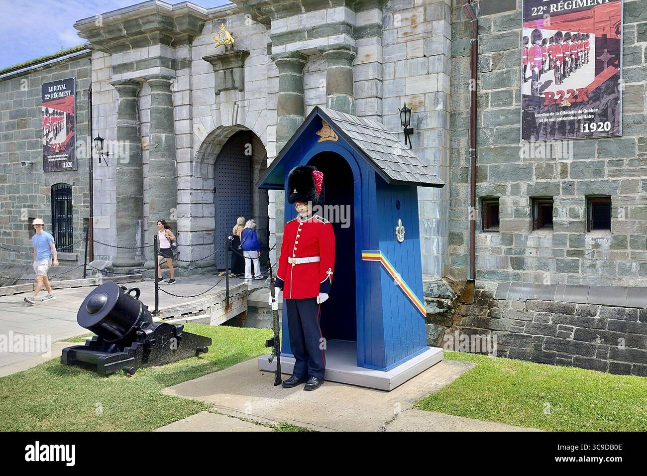 Guard stands at attention in front of a blue sentry box, dressed in a ...