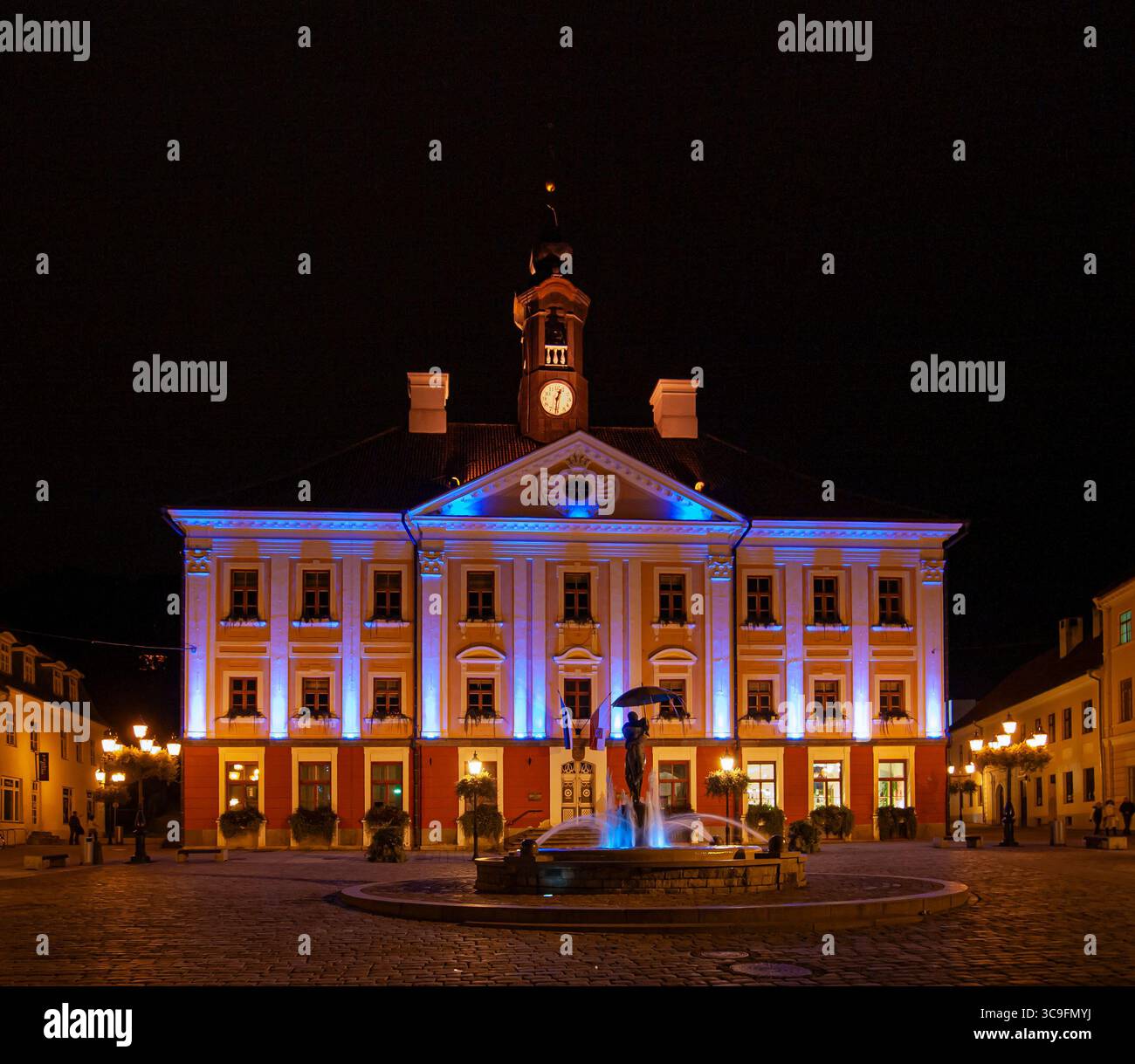 Tartu Town Hall at night with the Kissing Students fountain in front ...