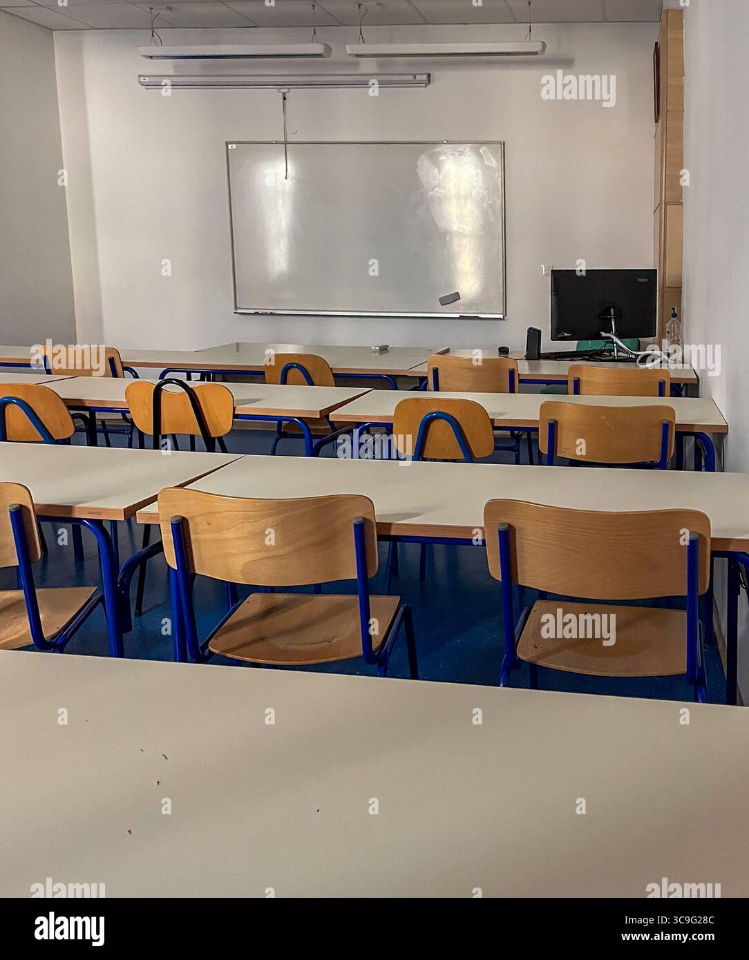 An elegant, minimalist classroom with flexible seating, digital screens ...