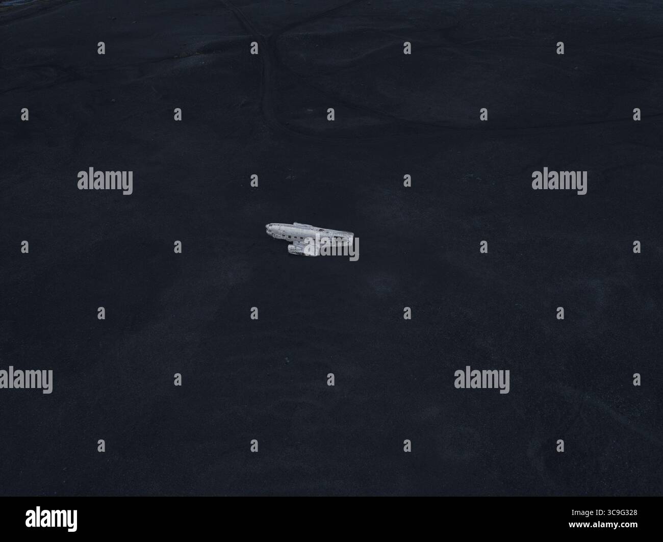 Aerial view of a small white structure standing out against the dark ...