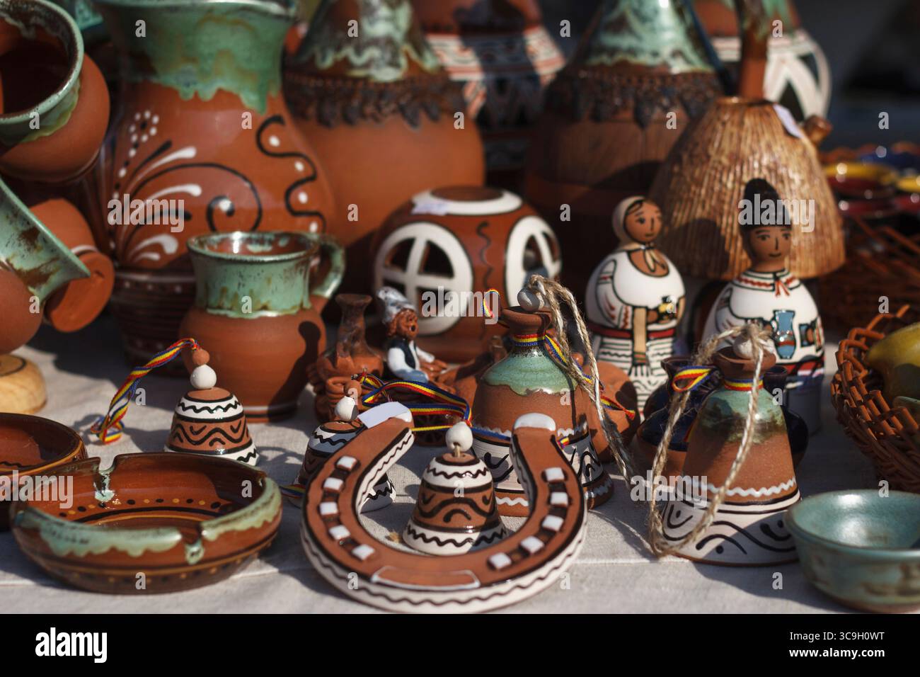 Colorful handmade pottery displayed at a market. Various shapes and ...