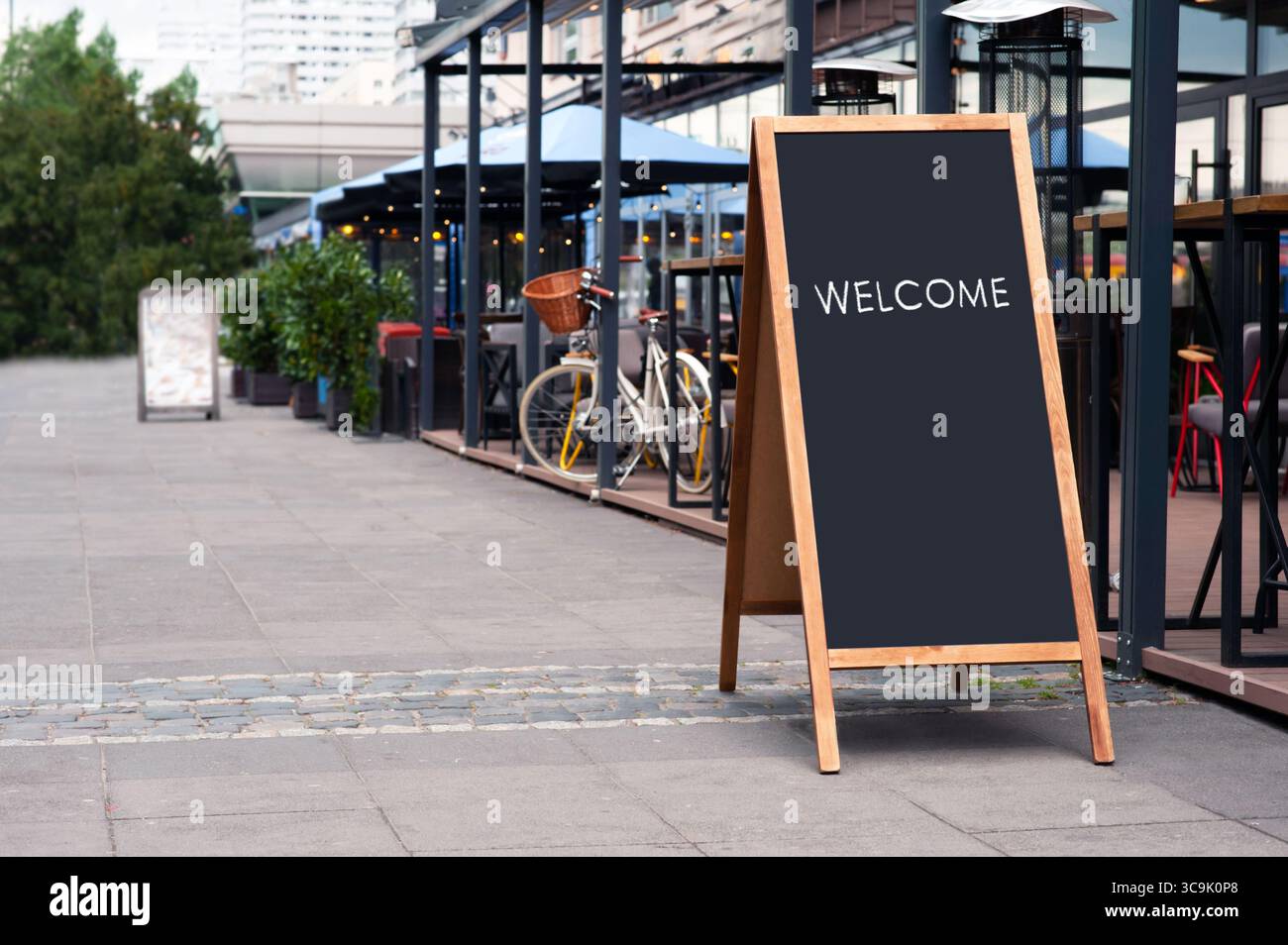 Advertising board with word Welcome near restaurant outdoor terrace ...