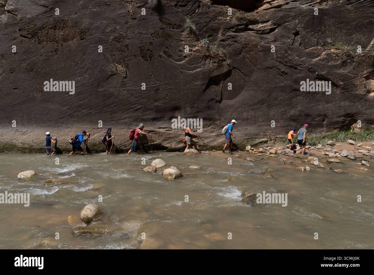 Hikers traverse the Virgin River in Zion National Park. The river walk ...