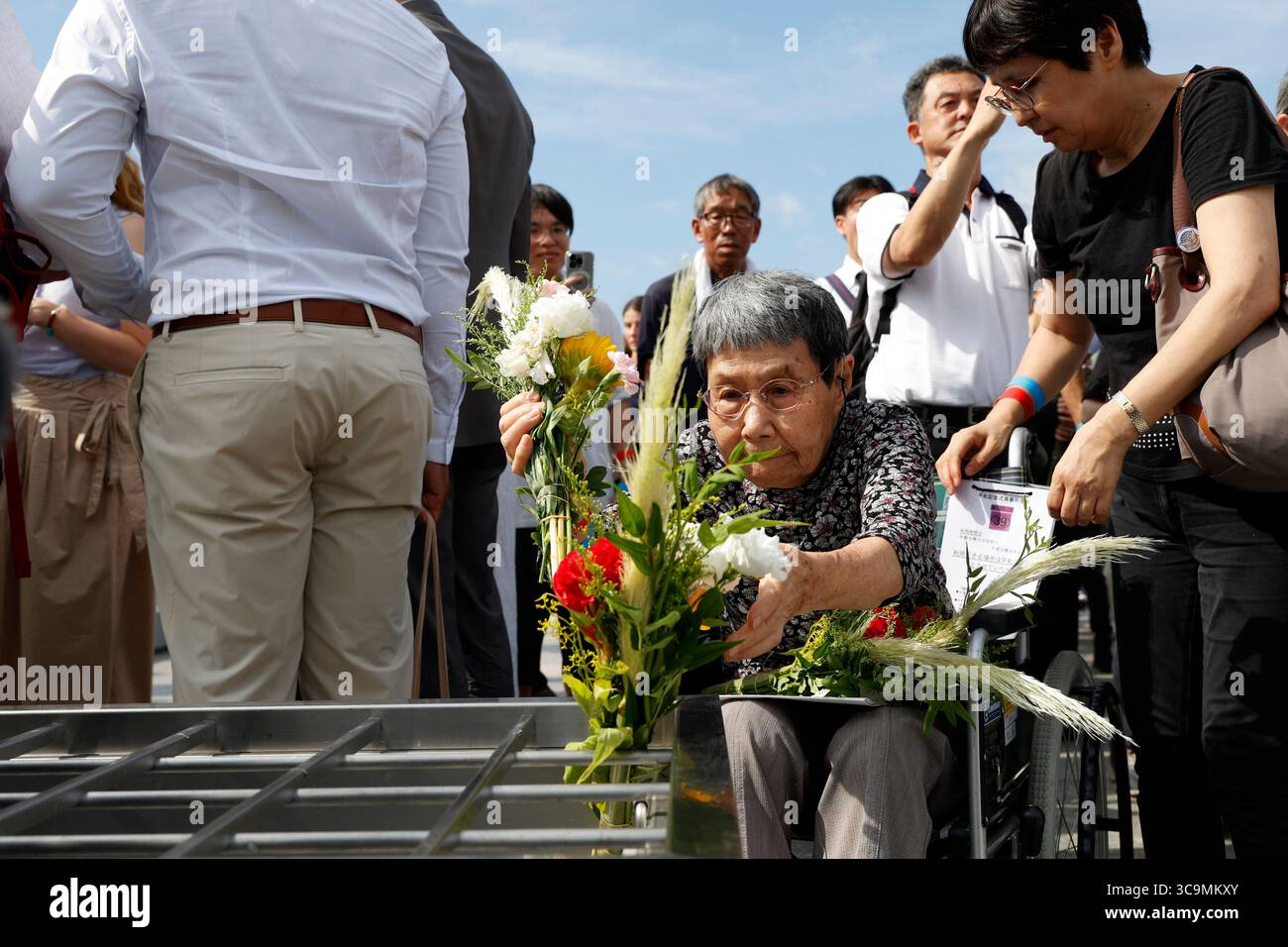 August 6, 2025, Hiroshima, Japan: A woman offers flowers after ending ...