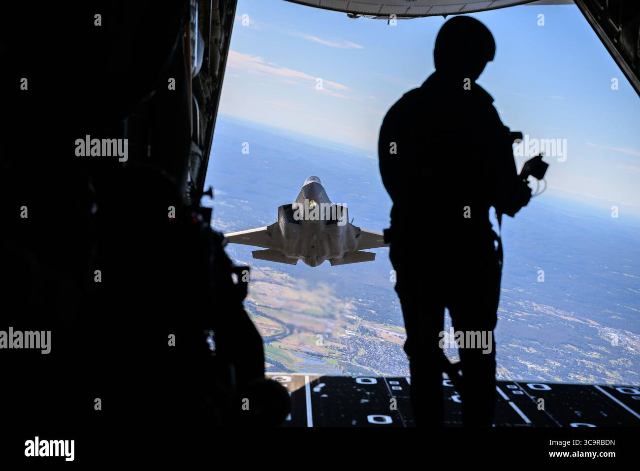A videographer is seen on the cargo ramp of a C-130J Hercules as a ...