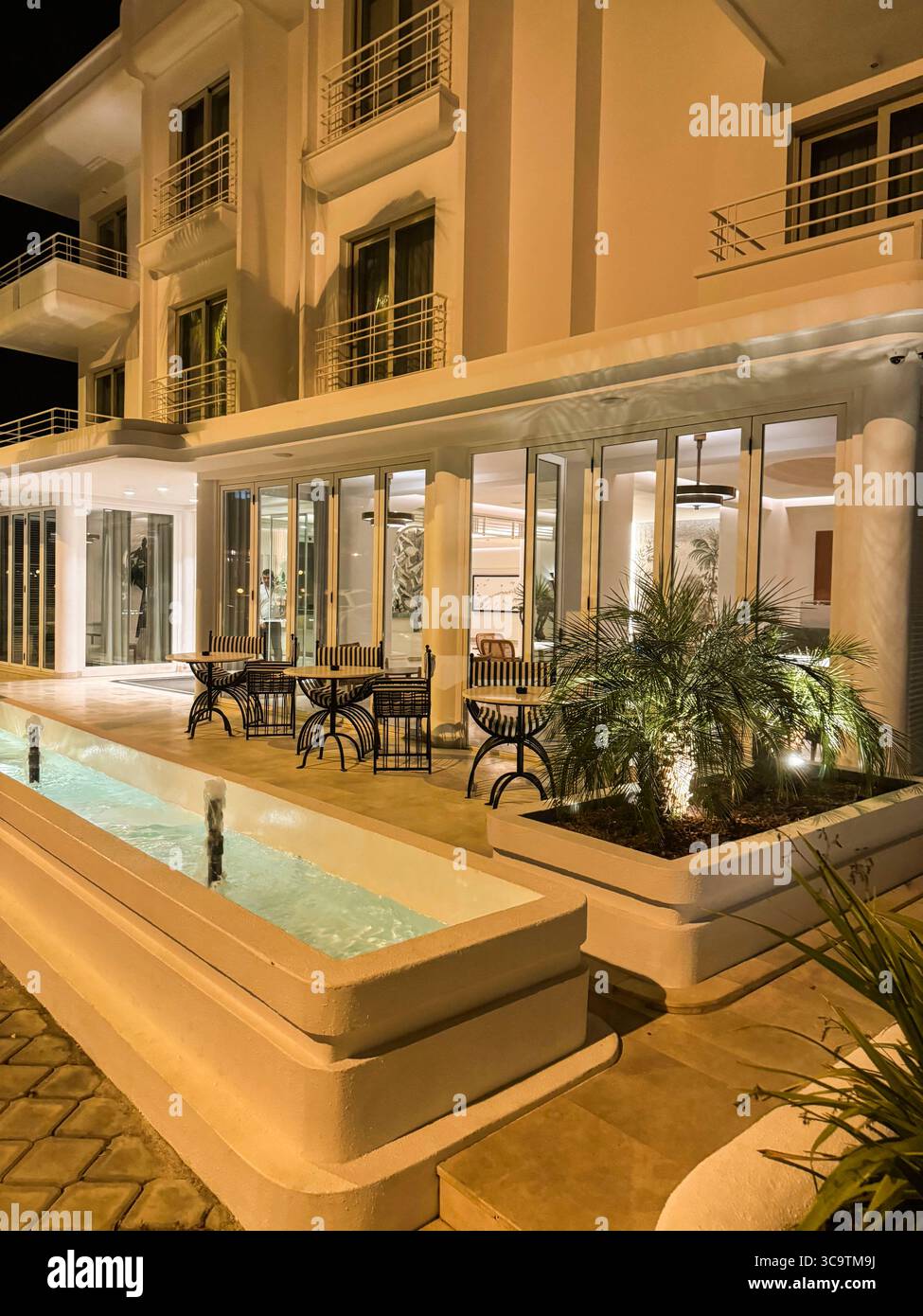 Luxury villa exterior with illuminated garden and water feature at ...