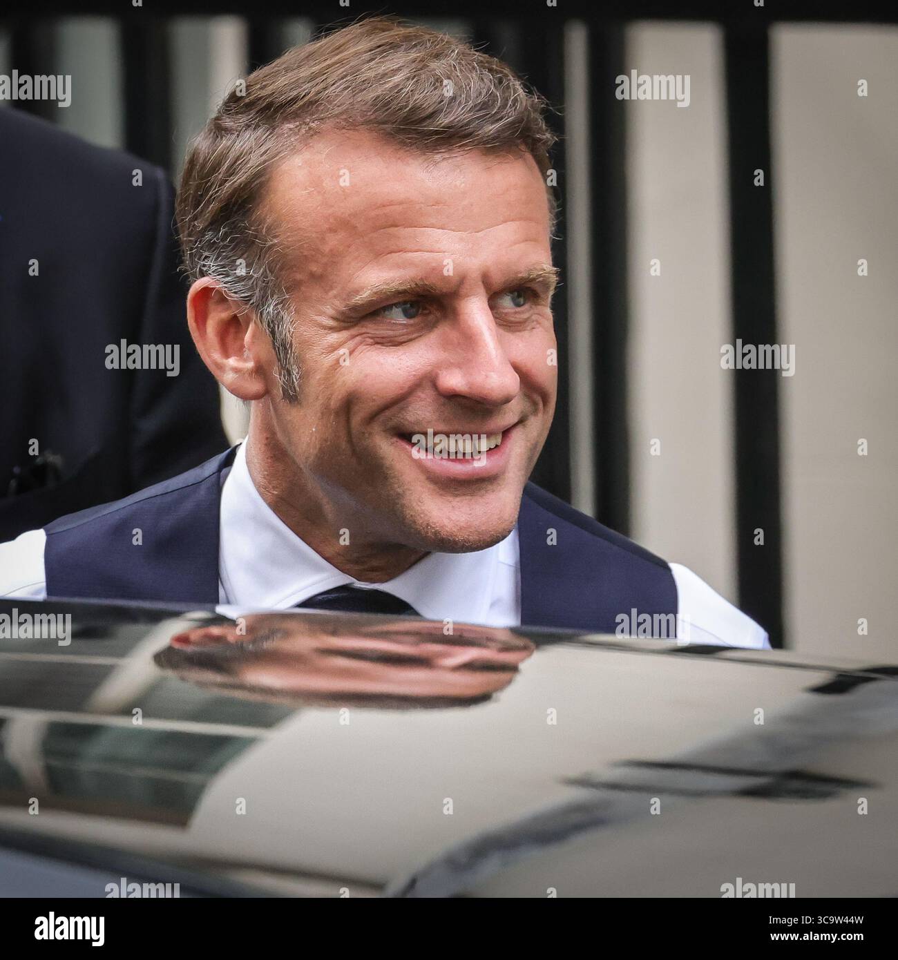 President of France Emmanuel Macron is reflected in car as he exits in ...