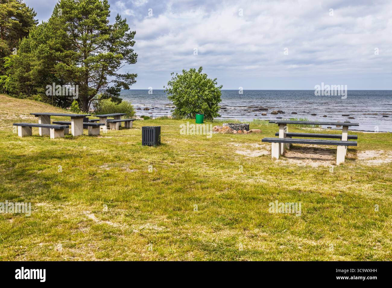 Baltic Sea picnic area with benches, fire pits and waves under cloudy ...