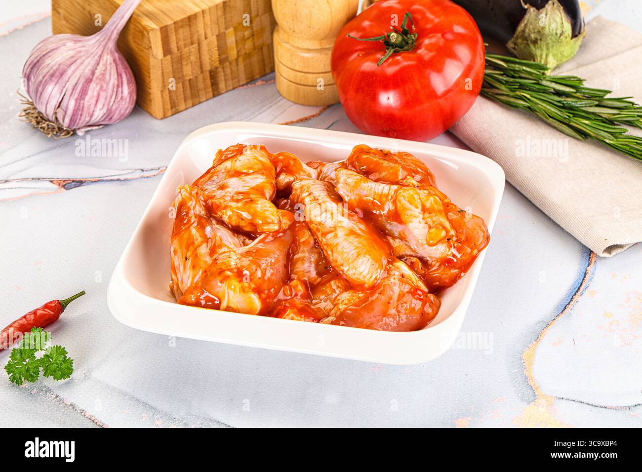 Raw marinated uncooked chicken wings for grill Stock Photo - Alamy