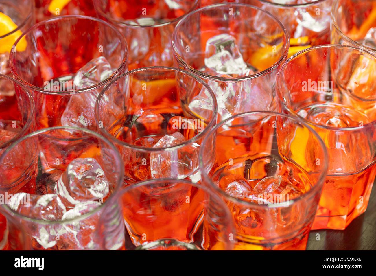Many glasses filled with a refreshing Aperol spritz cocktail and ice ...