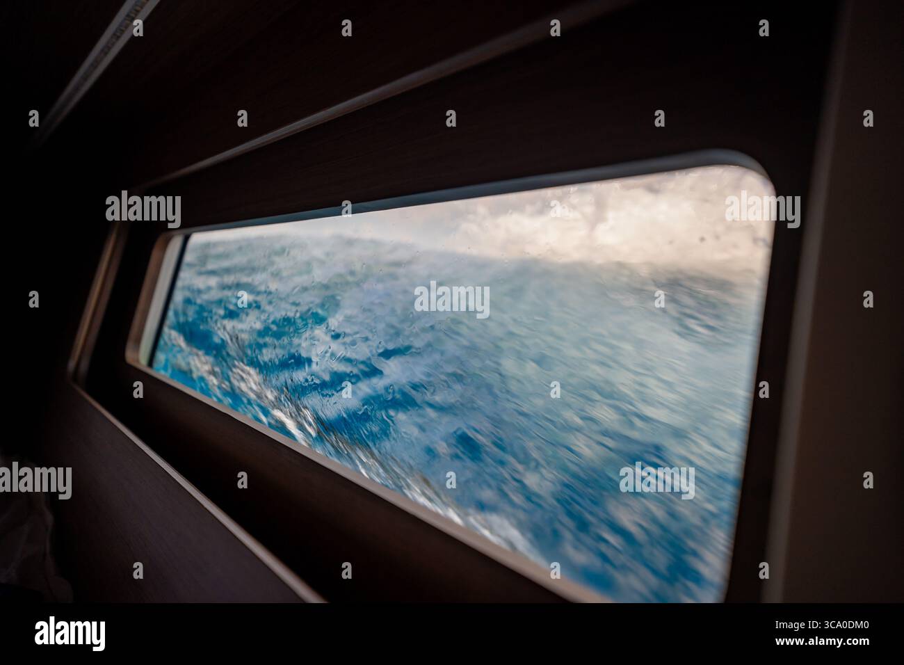 View through the bow cabin window of a sailing yacht leaning into the ...