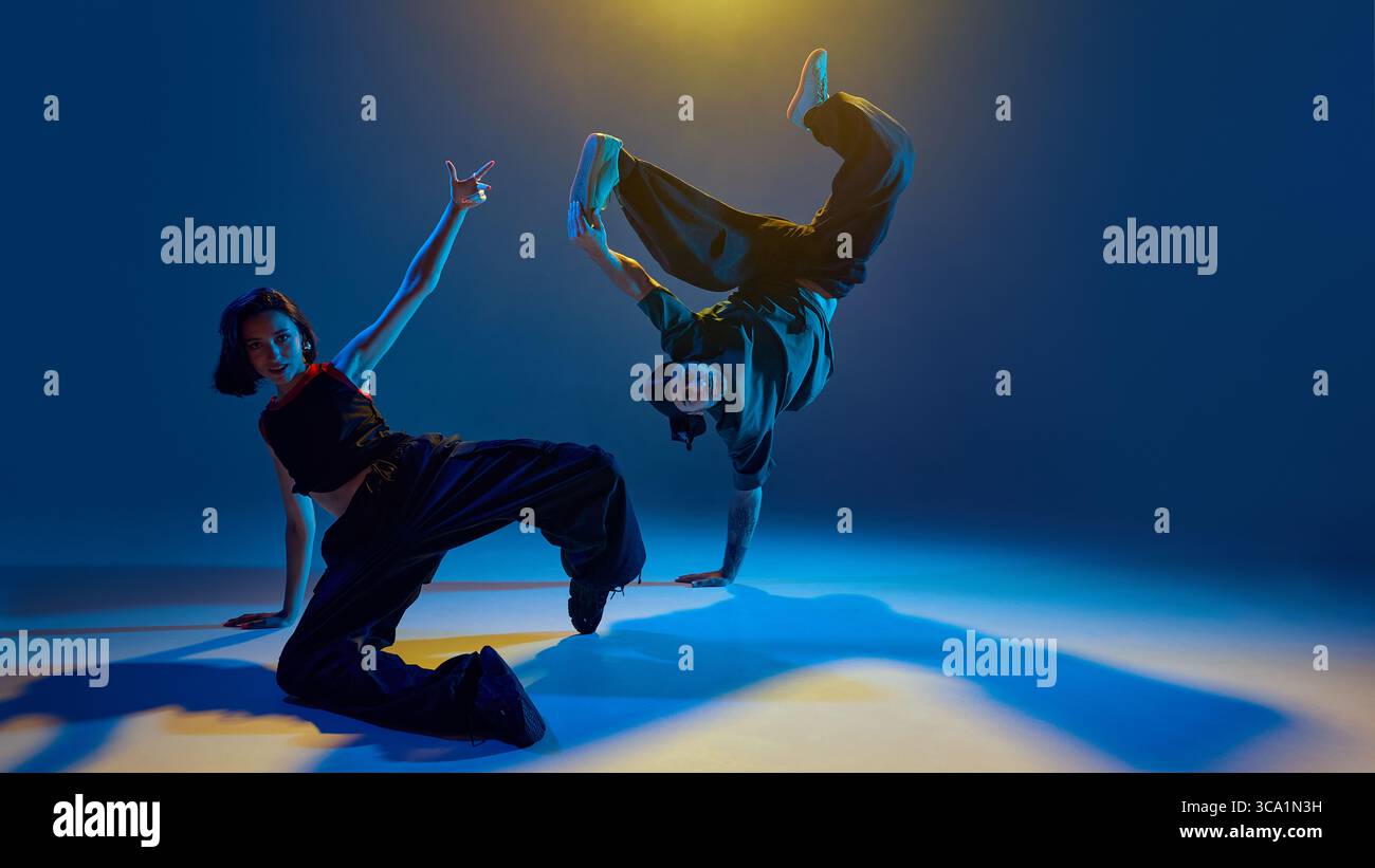 Dancers freezing in intense floor pose with raised limbs and direct eye ...