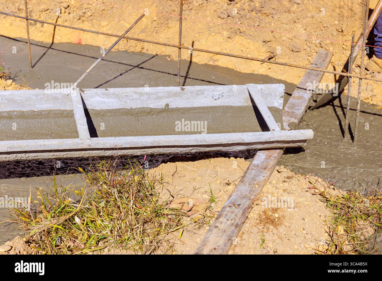 Construction crew is pouring fresh concrete into forms at construction ...