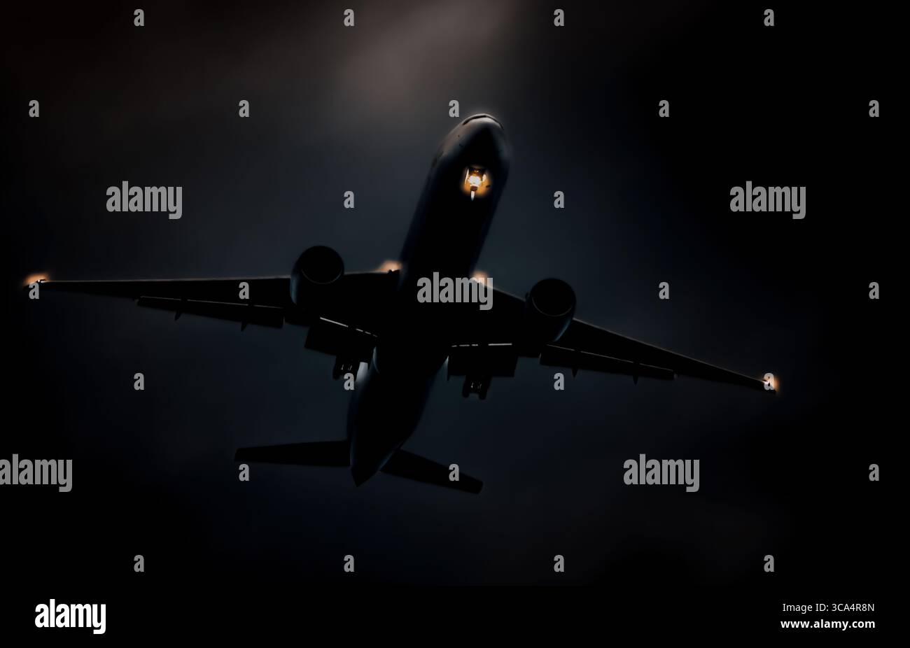a plane flying in the night sky with lights on board Stock Photo - Alamy
