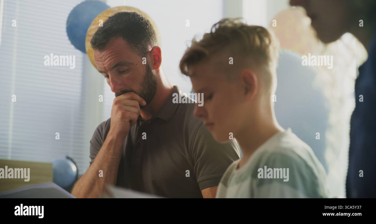 Parents Looking at School Exam Grades of Their Son in Classroom ...
