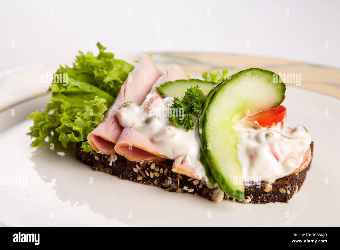 classic Danish smørrebrød featuring savory ham, crisp cucumber, fresh ...