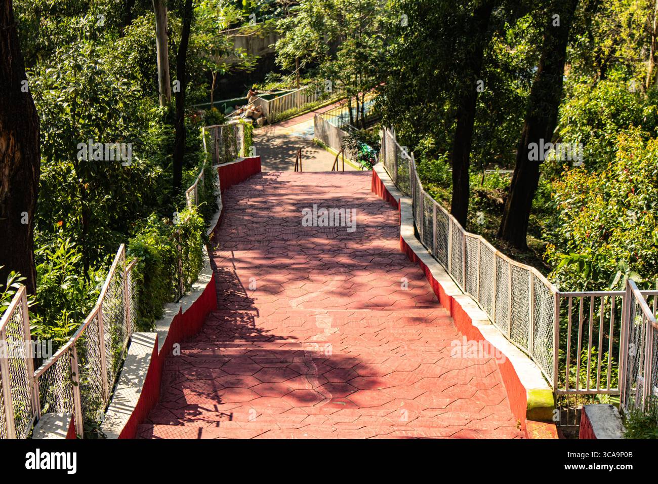 Red Climbing Steps Cutting Through Green Mountain Stock Photo - Alamy
