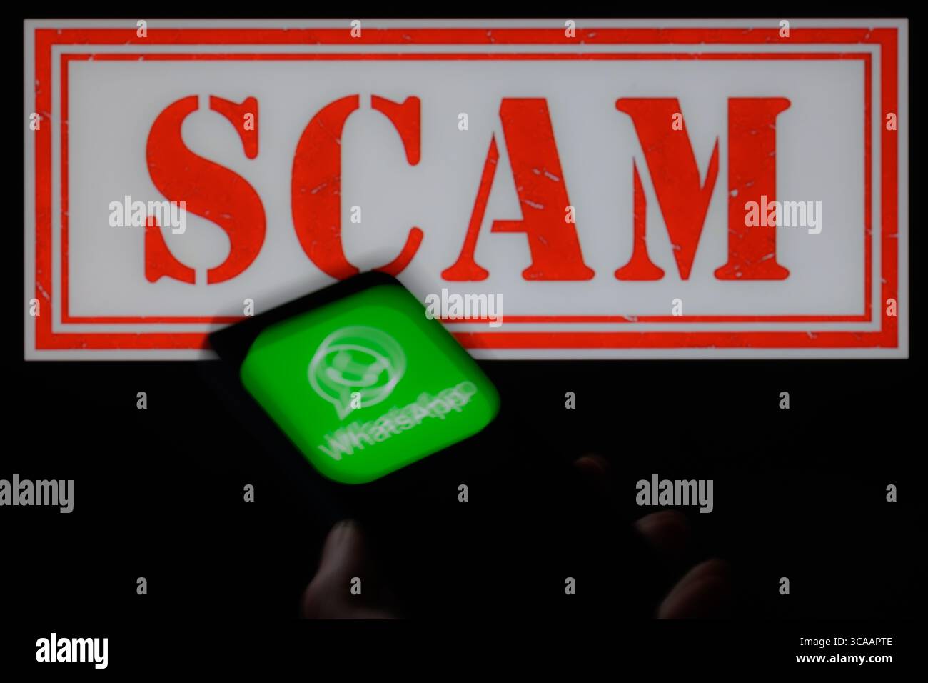 The WhatsApp logo is being displayed on a mobile phone with scam seen ...
