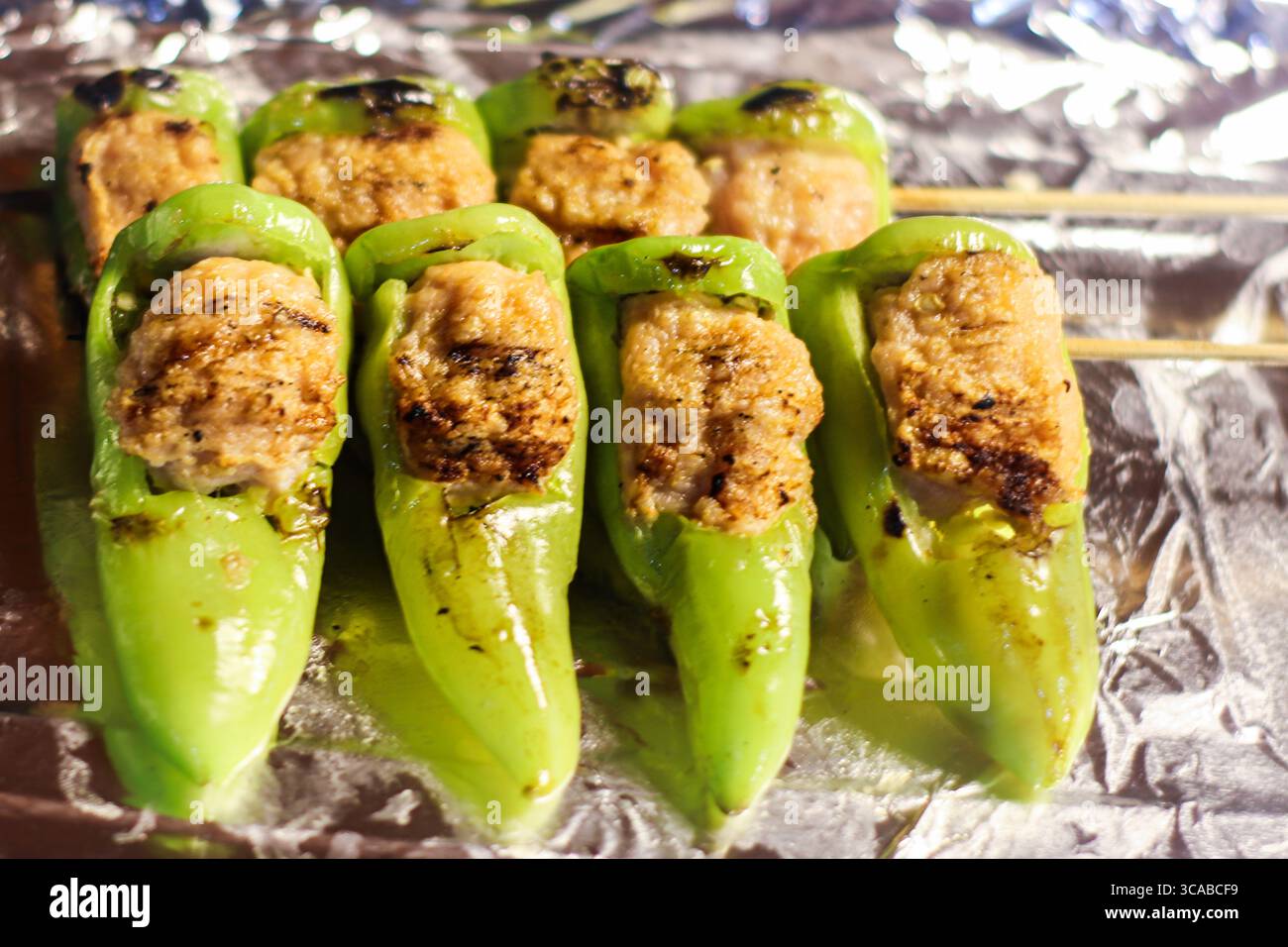 Grilled stuffed chili peppers with minced meat on foil, Thai night ...