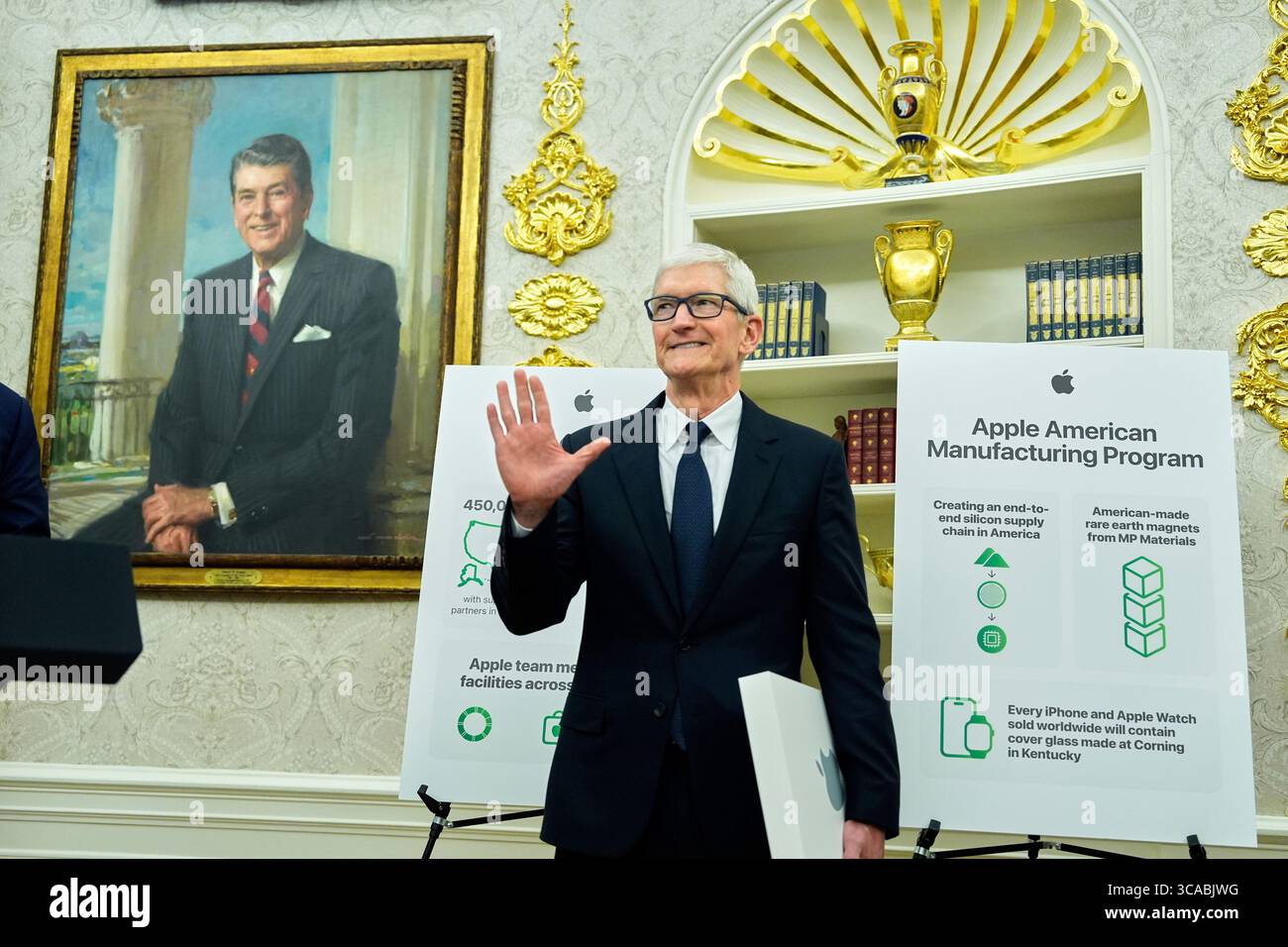 Apple CEO Tim Cook waves in the Oval Office as President Donald Trump ...